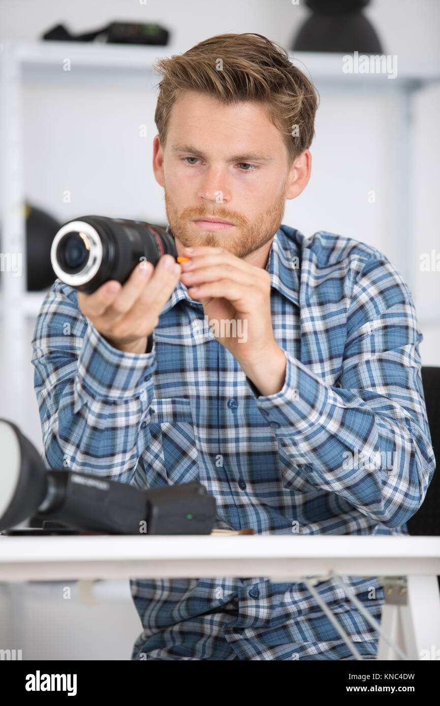 young man checking lens of his camera Stock Photo - Alamy