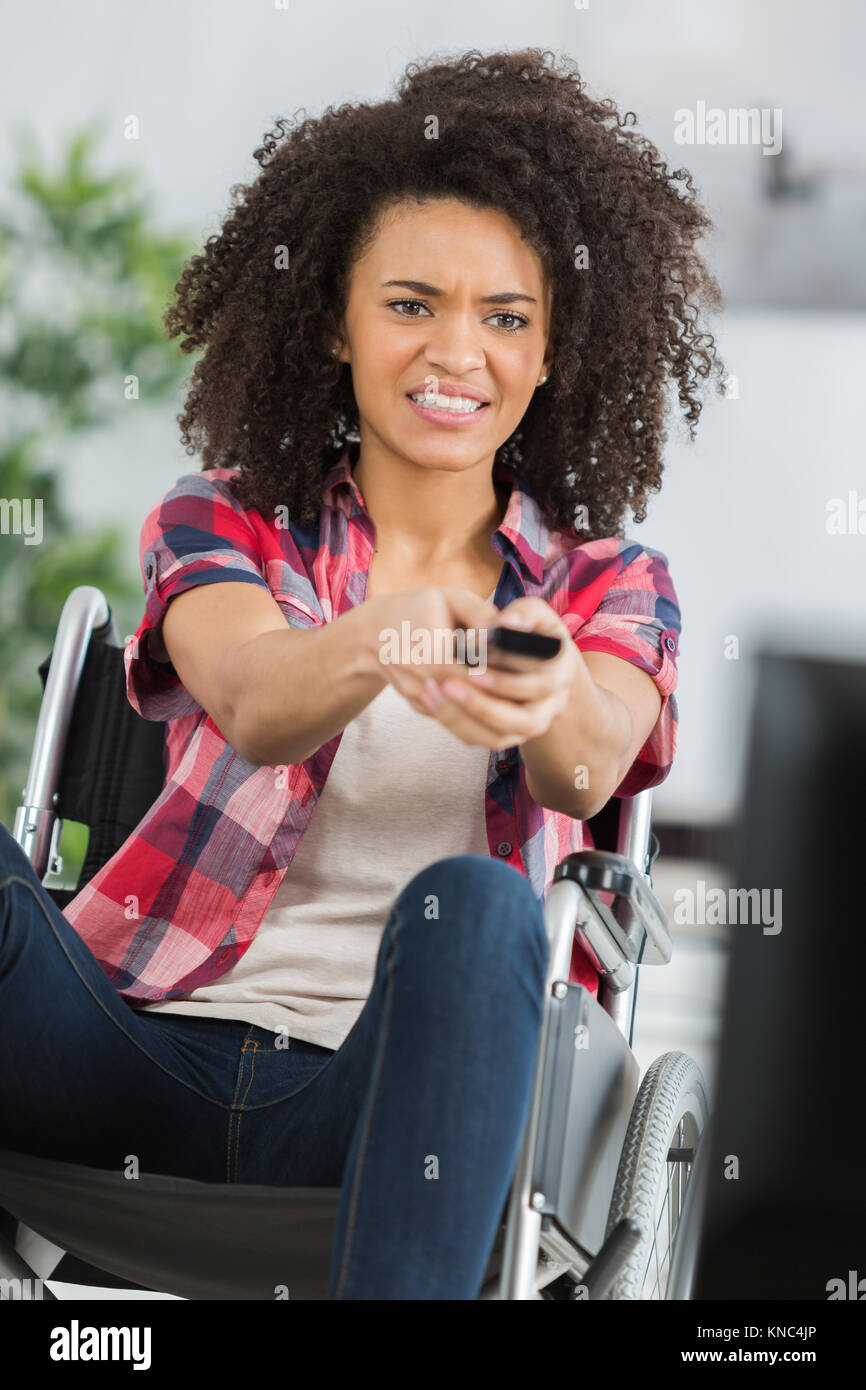 Lady in wheelchair having difficulty with remote control Stock Photo ...