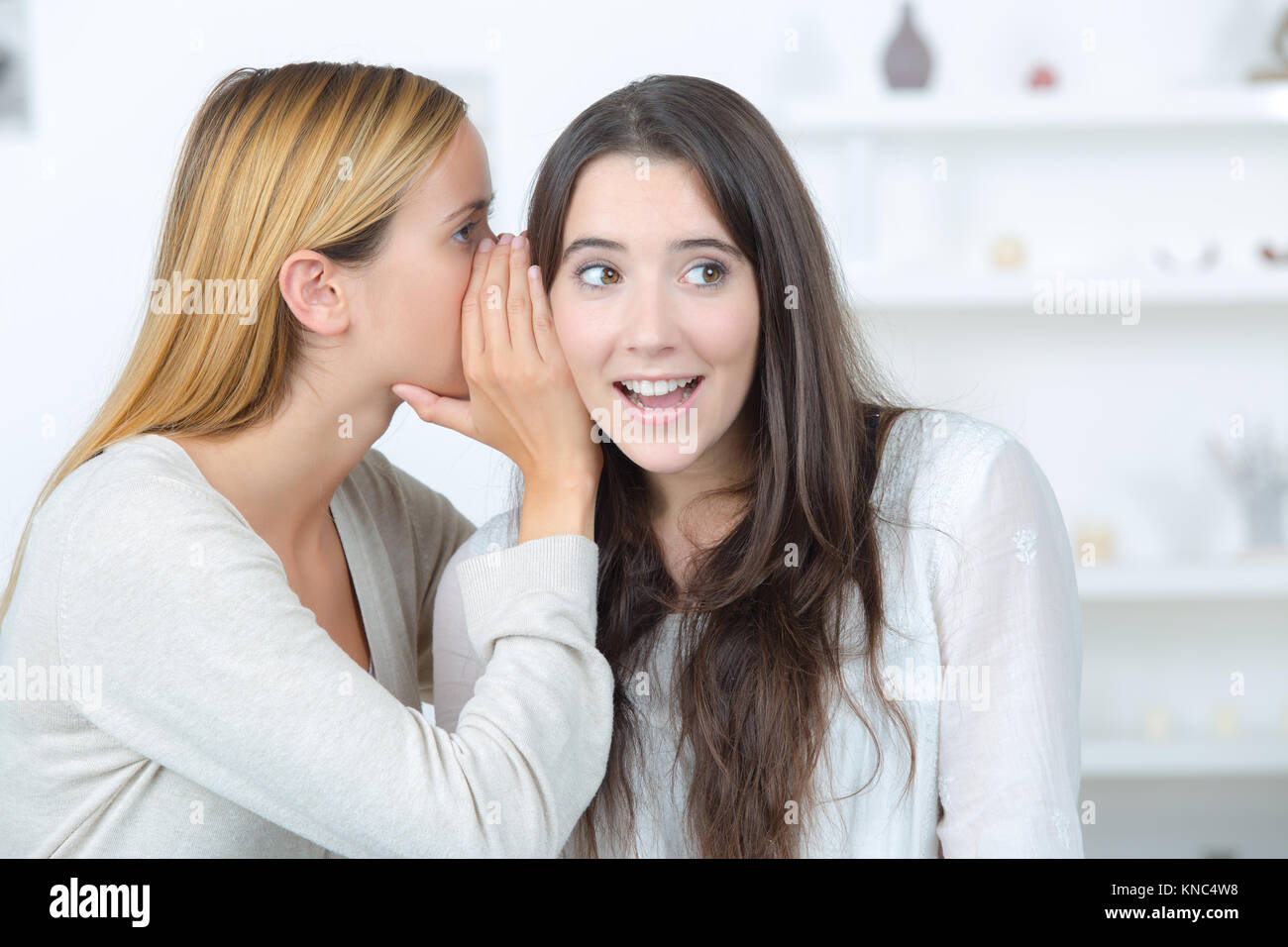 girl telling a secret in the ear of her friend Stock Photo - Alamy