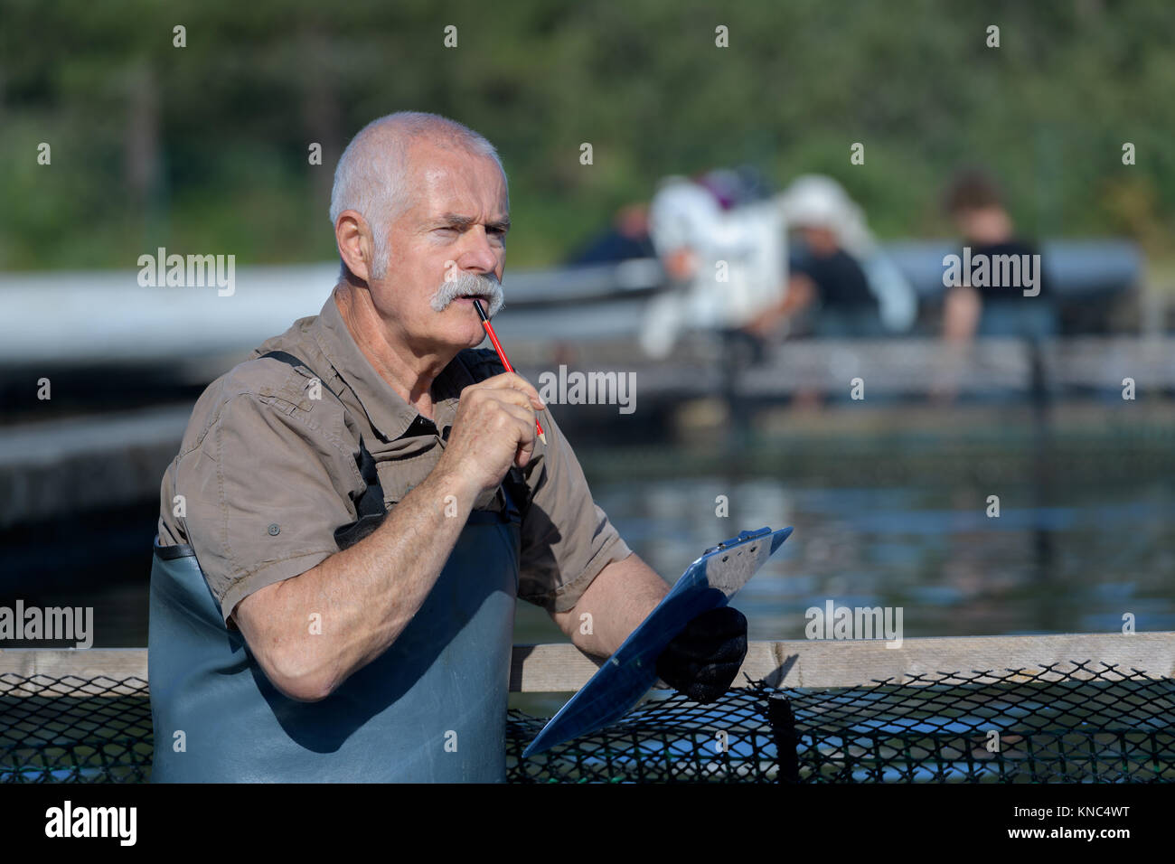 thoughful fisherman at fish farm Stock Photo - Alamy