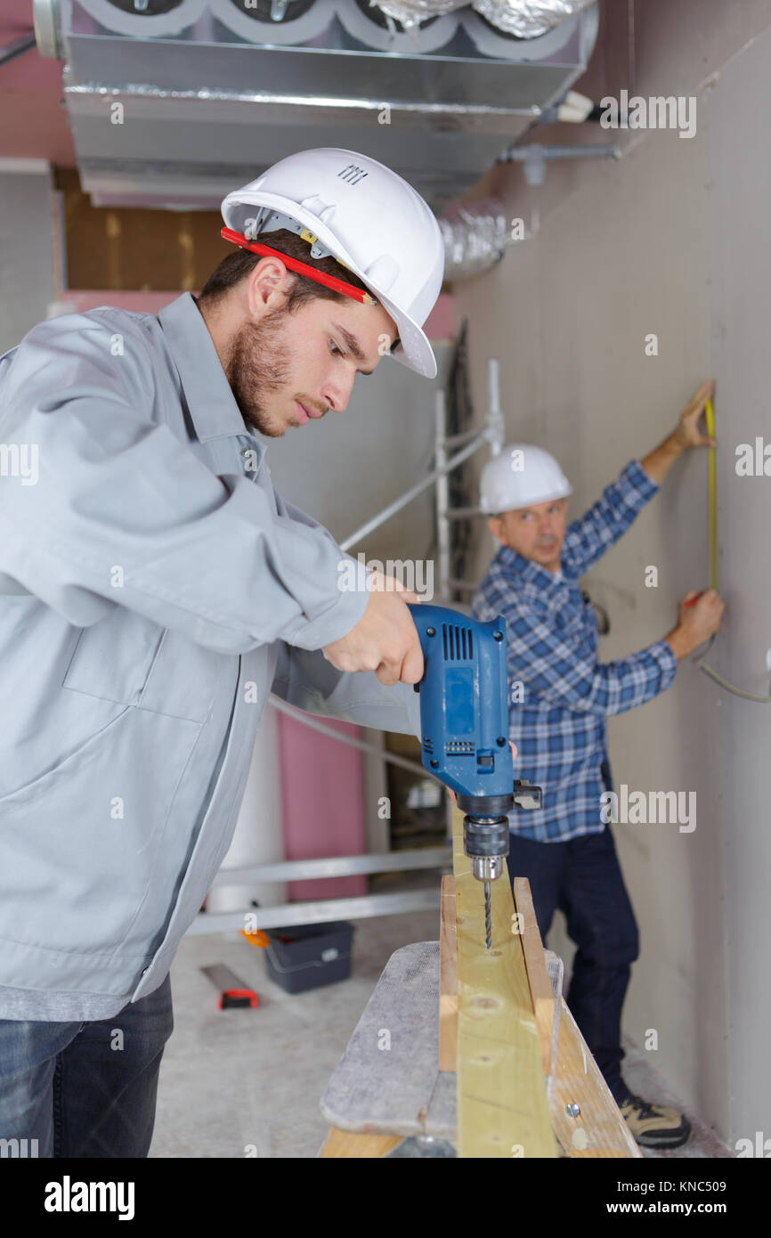 young carpenter drilling Stock Photo - Alamy