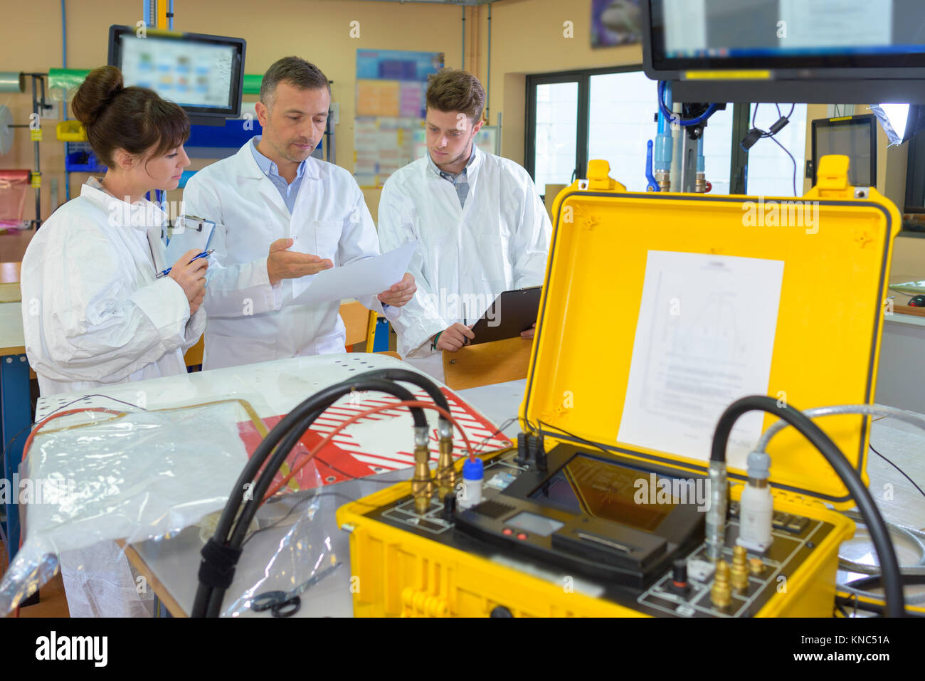 People in workshop, electrical powerpack in foreground Stock Photo - Alamy