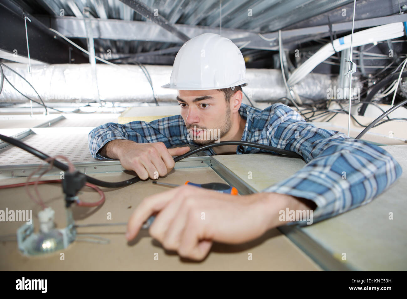 man repairing electrical wiring on the ceiling Stock Photo - Alamy