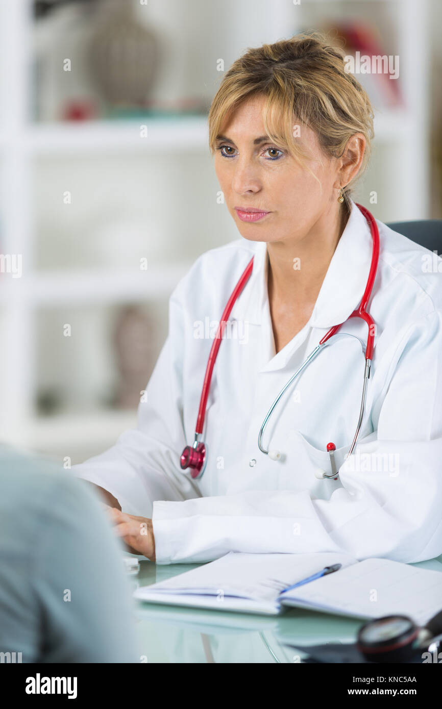 Doctor typing while with patient Stock Photo - Alamy