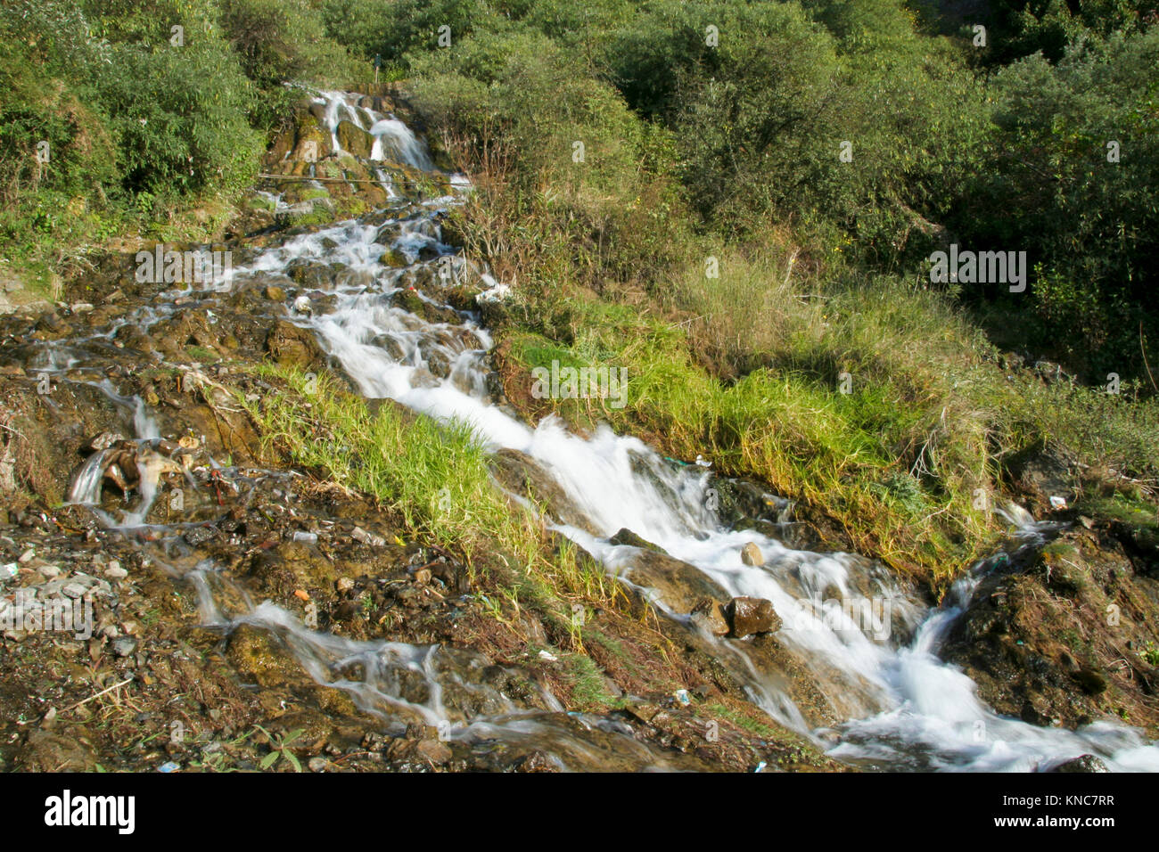 White frozen flow of water down the green inclined hill Stock Photo - Alamy