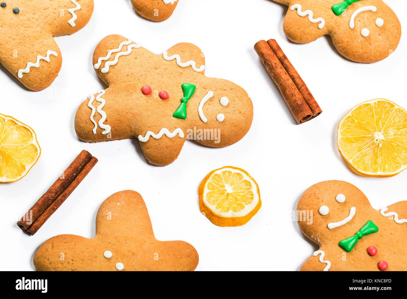 Christmas gingerbread men with lemon and cinnamon sticks on white ...