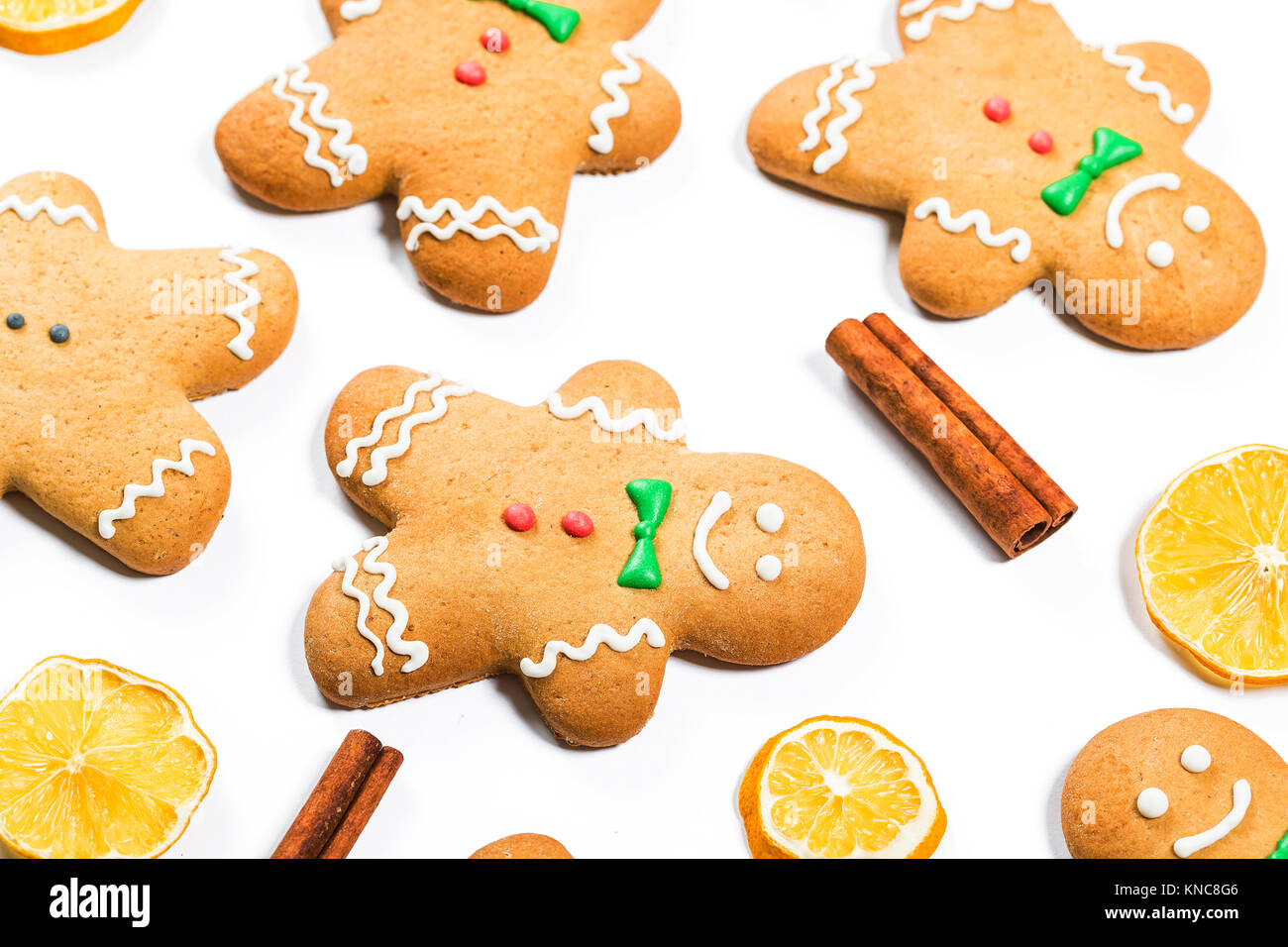 Christmas gingerbread men with lemon and cinnamon sticks on white ...