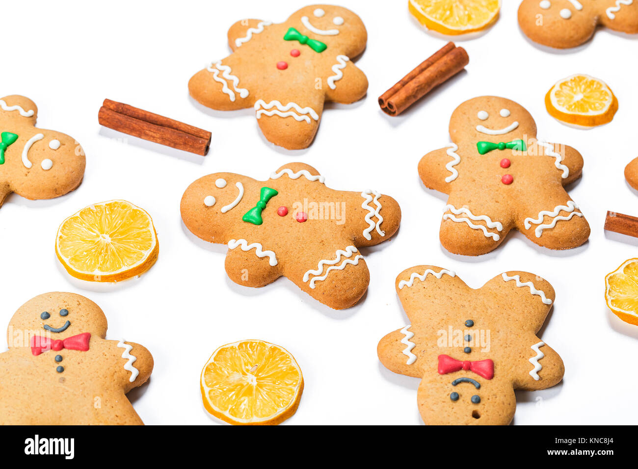 Christmas gingerbread men with lemon and cinnamon sticks on white ...