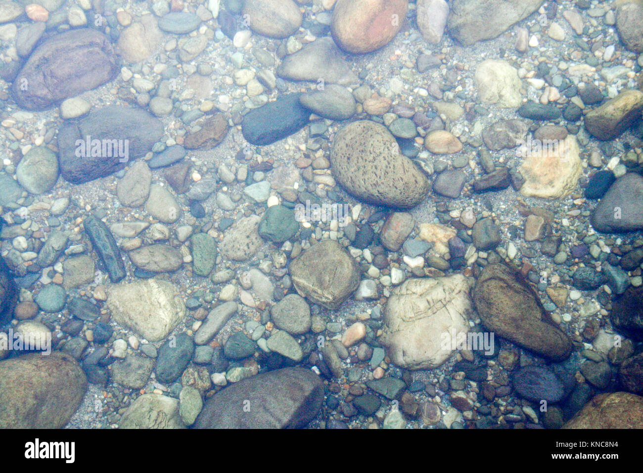 Pebbles seen through layer of clear deep water Stock Photo - Alamy