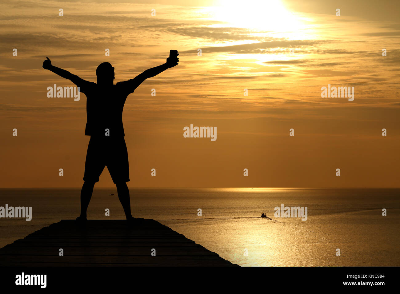 Silhouette of man raising hands at sunset Stock Photo - Alamy