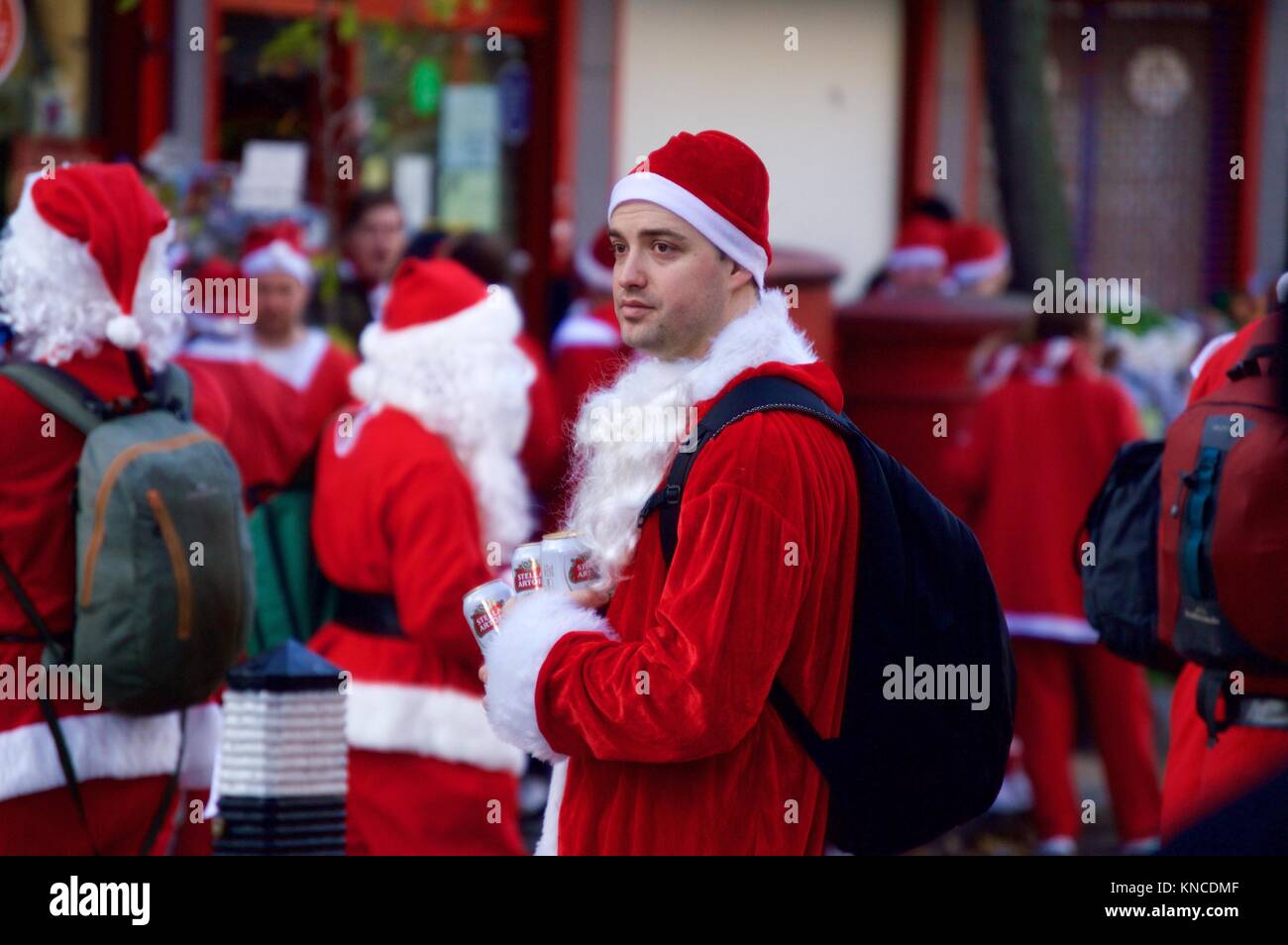 Flash mob dressed as Santa Claus walking through London, drinking and ...