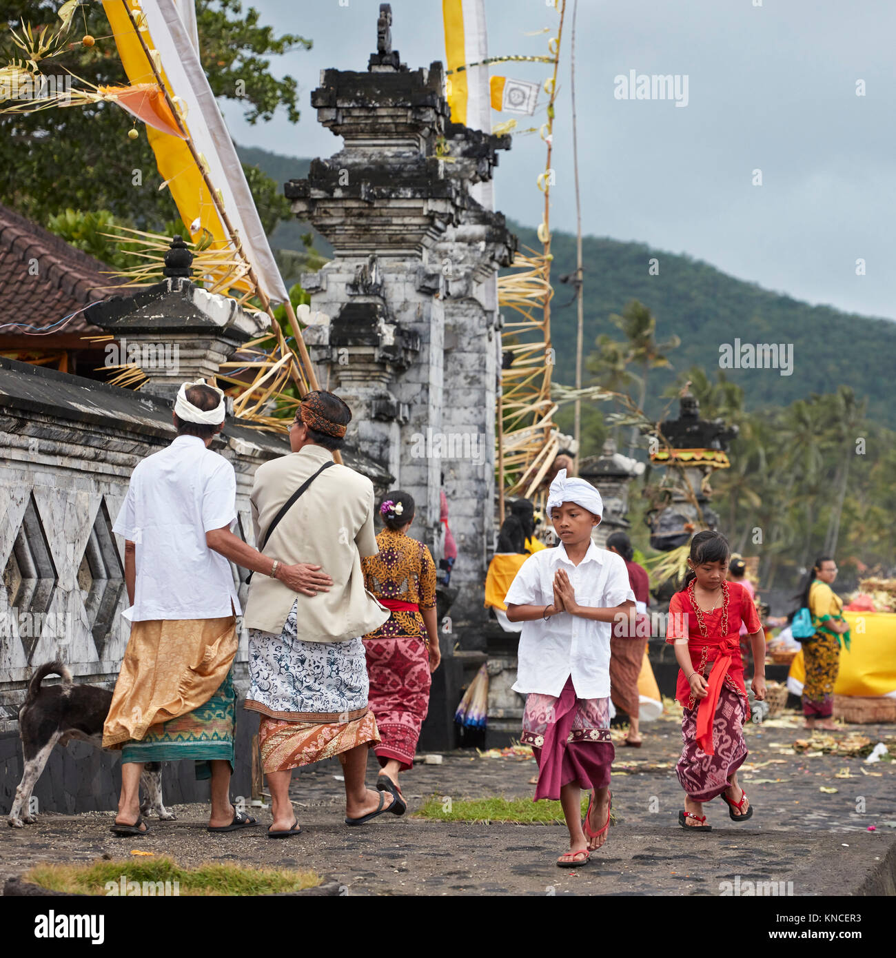 People wearing traditional Balinese clothing in front of a local temple ...
