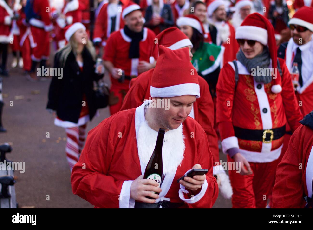 Flash mob dressed as Santa Claus walking through London, drinking and ...
