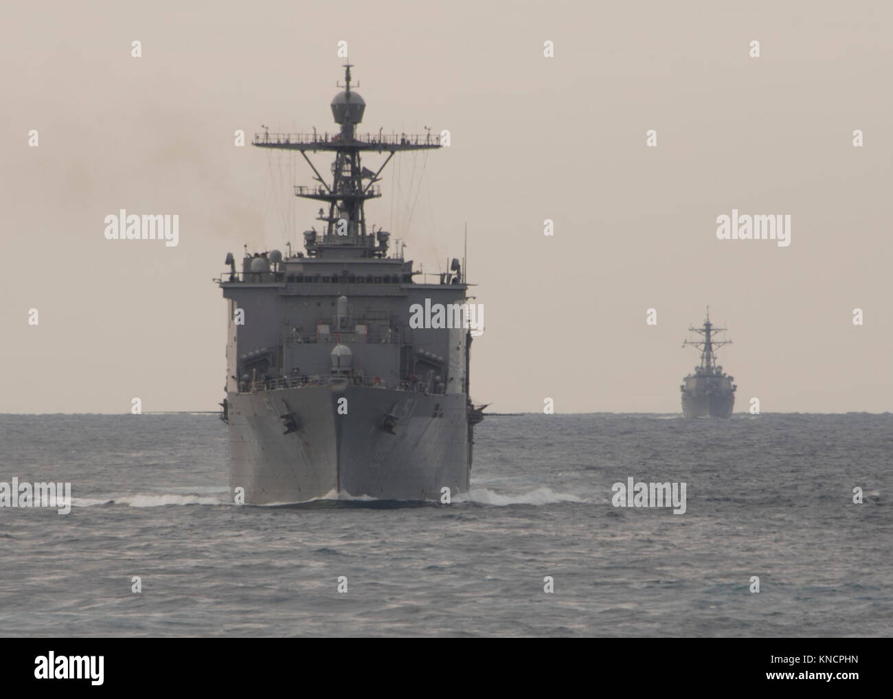 The amphibious transport dock ship USS Oak Hill (LSD 51) (front) and ...