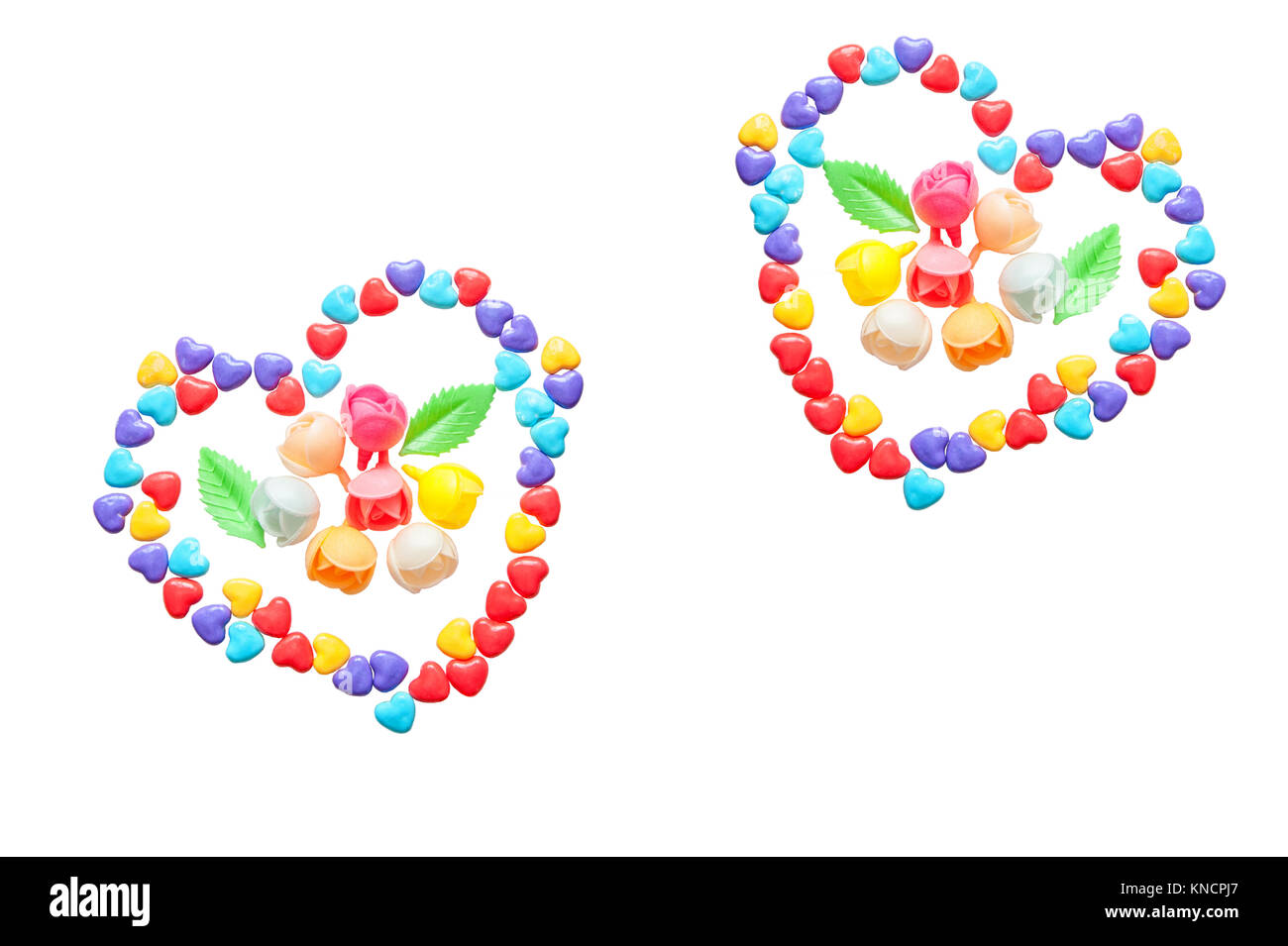 Two hearts of little colorful candy hearts. Caramelized flowers ...