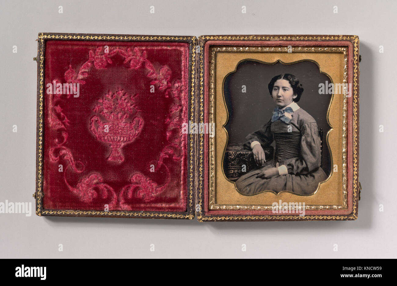 This portrait shows a seated young woman with a large bow collar ...