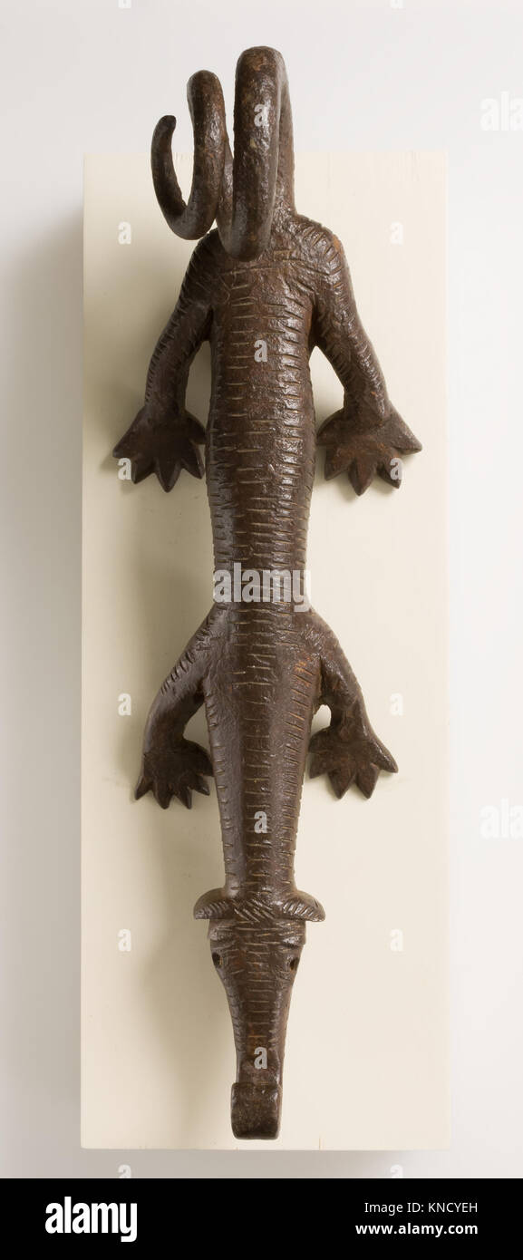 This door knocker is designed in the form of a lizard-like creature ...