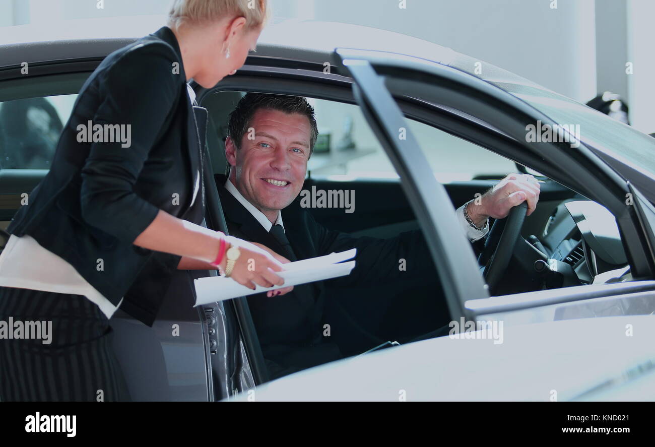 Handsome successful man buying a car at dealership Stock Photo - Alamy