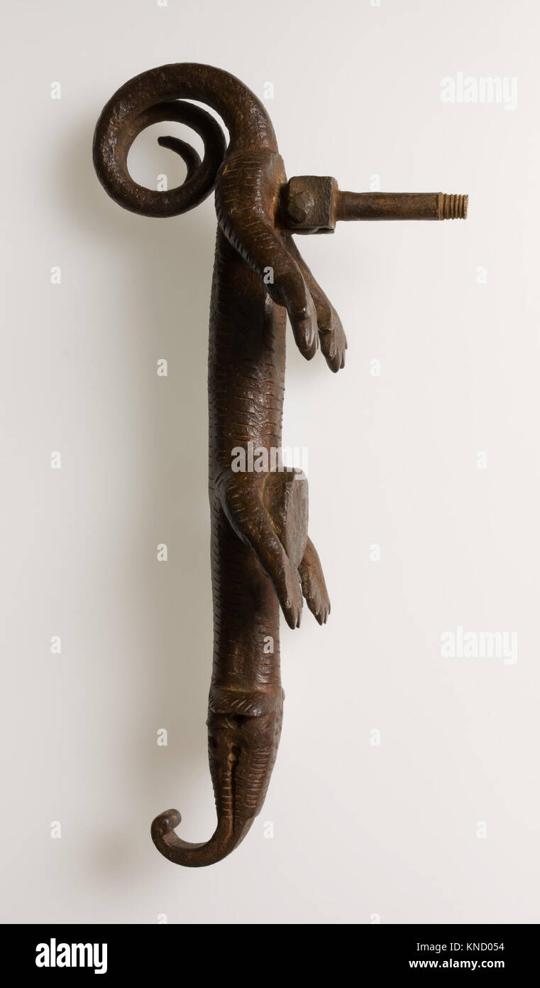 This door knocker, designed in the form of a lizard-like creature, is a ...