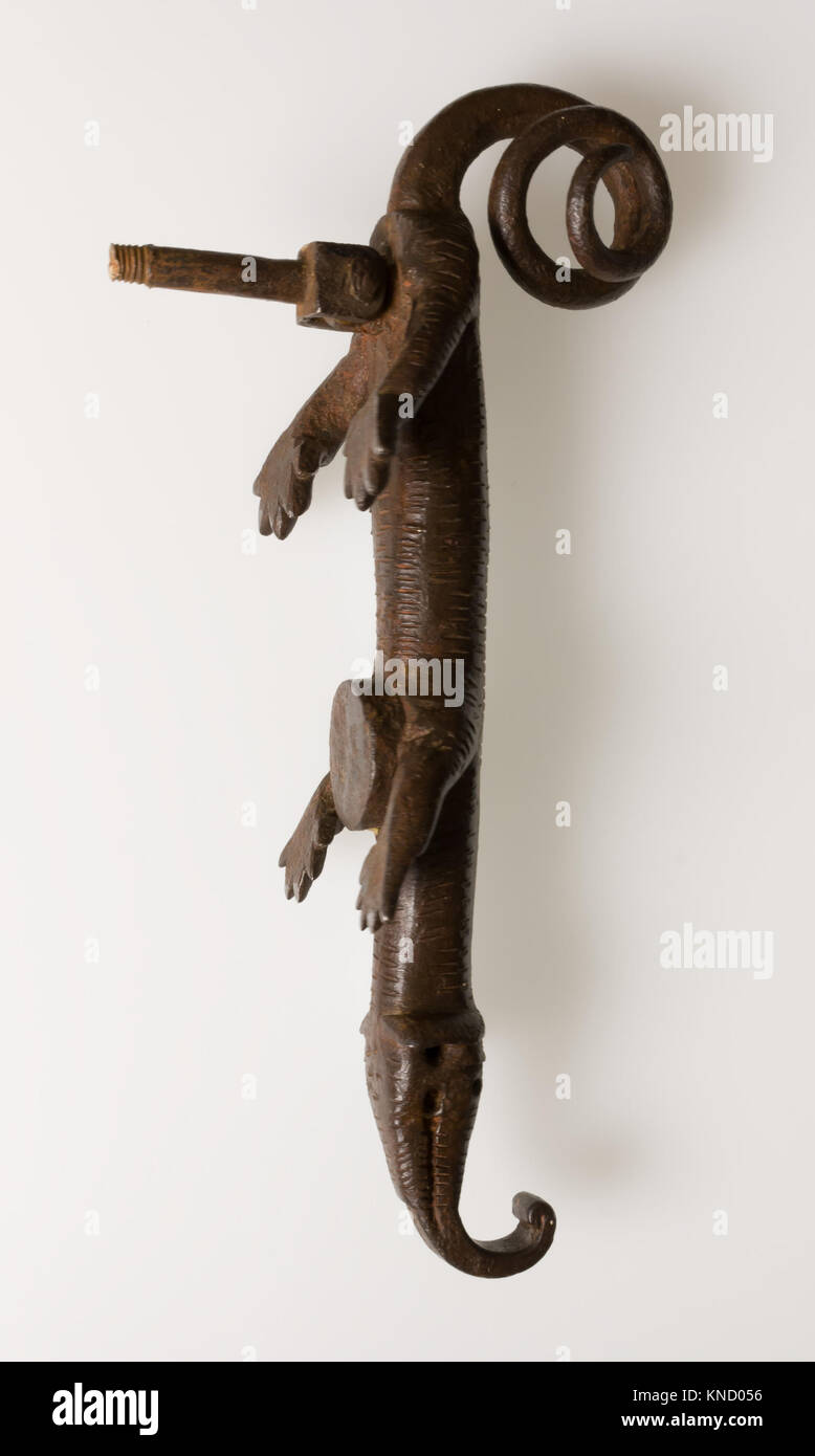 This door knocker is designed in the shape of a lizard-like creature ...