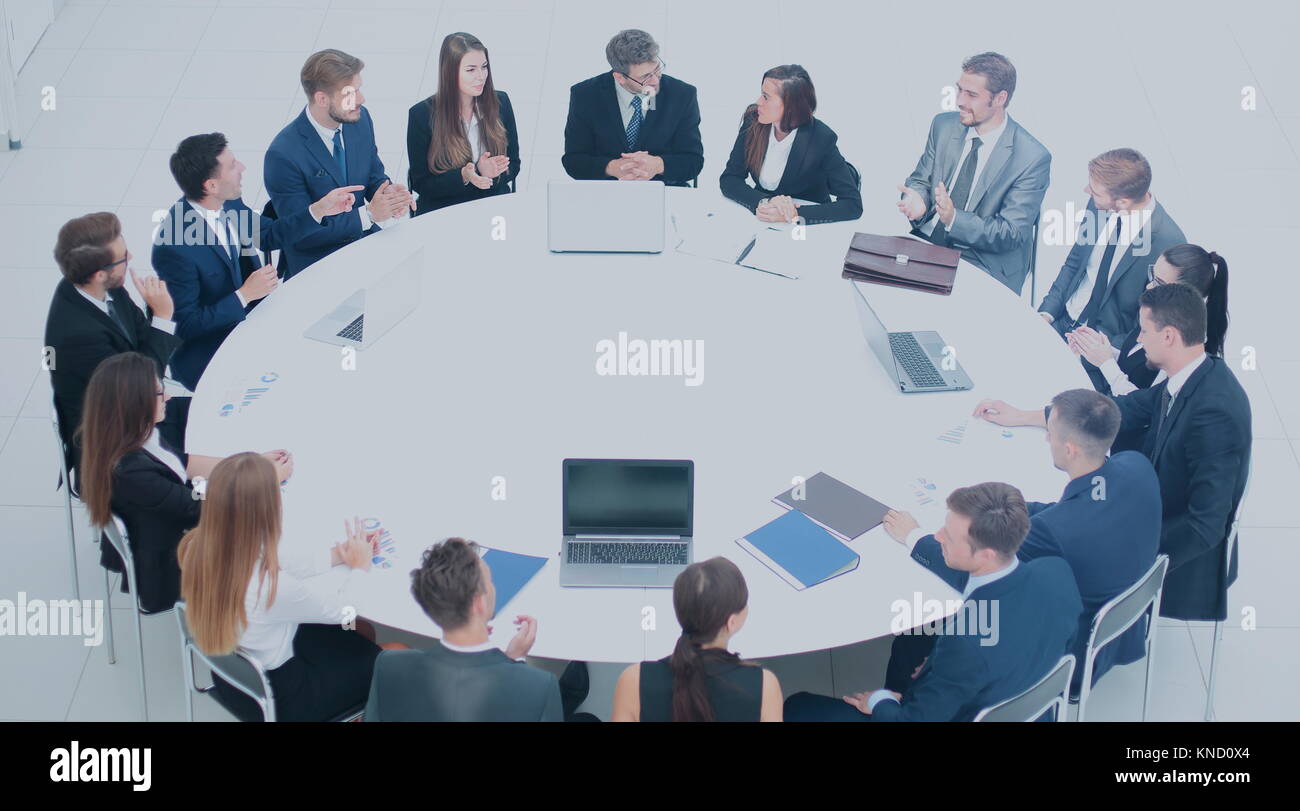 business partners and working groups sitting at a round table and ...