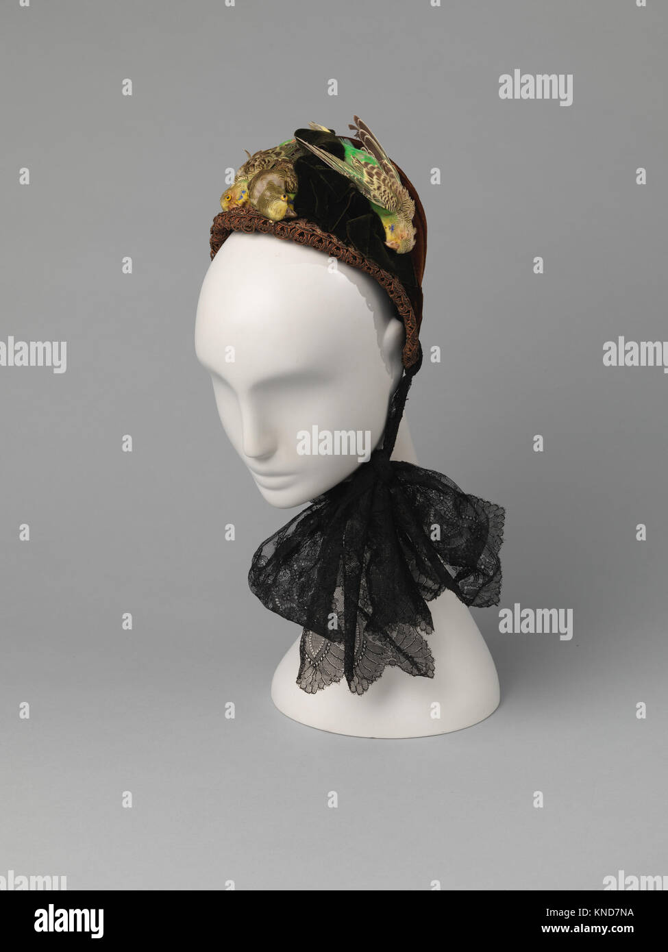This 1890s bonnet, crafted from silk and adorned with feathers, is a ...