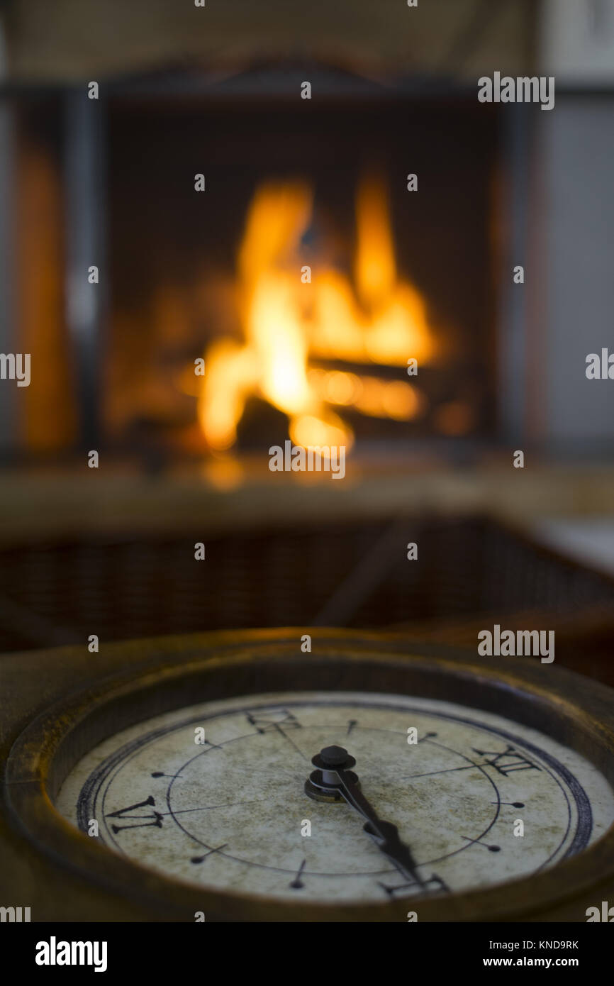 concept of time with an ancient clock in front at a fireplace Stock ...