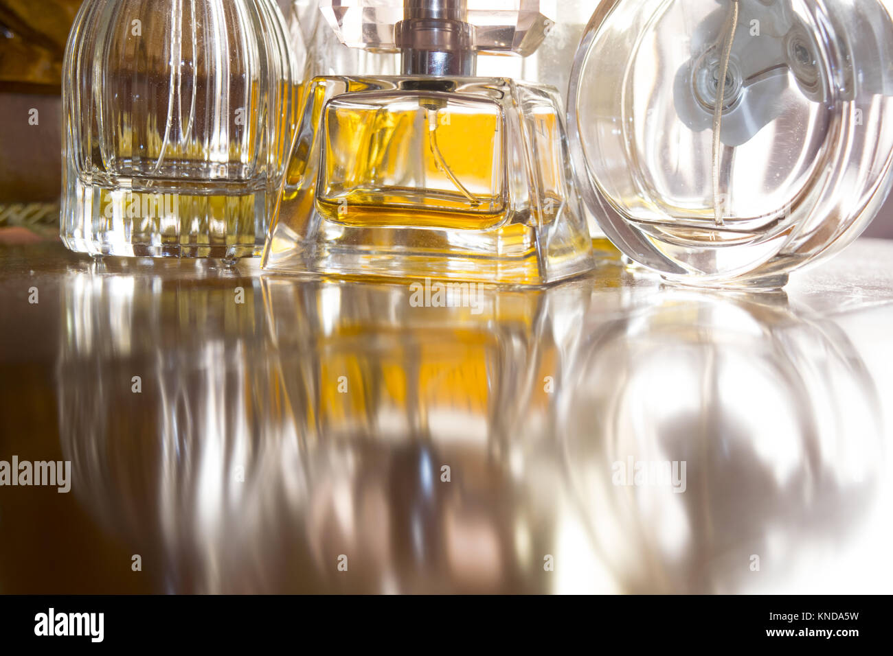 perfume bottles in back-lit on a wooden background and reflections of ...