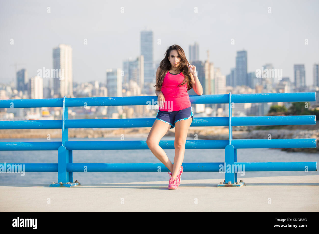 Beautiful Aactive woman resting on the fence hand touching hair Stock ...