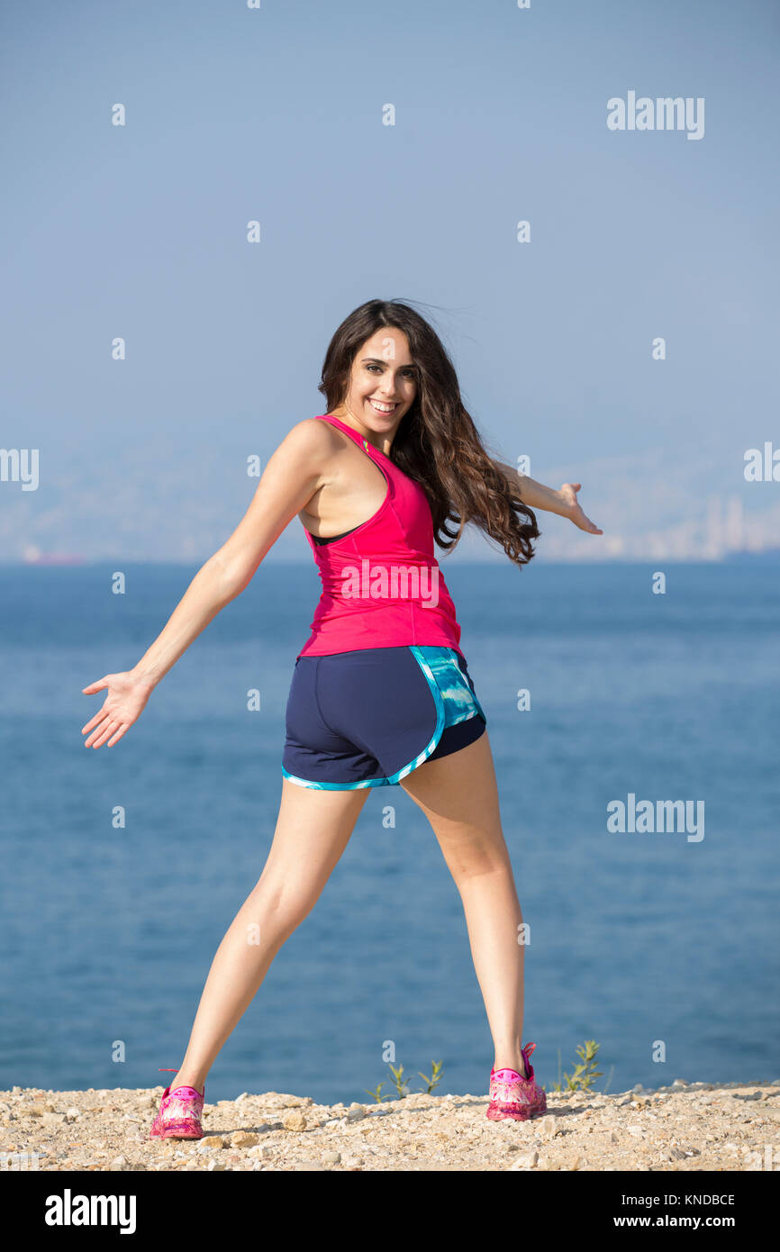 Healthy young woman exercising on the beach Stock Photo - Alamy