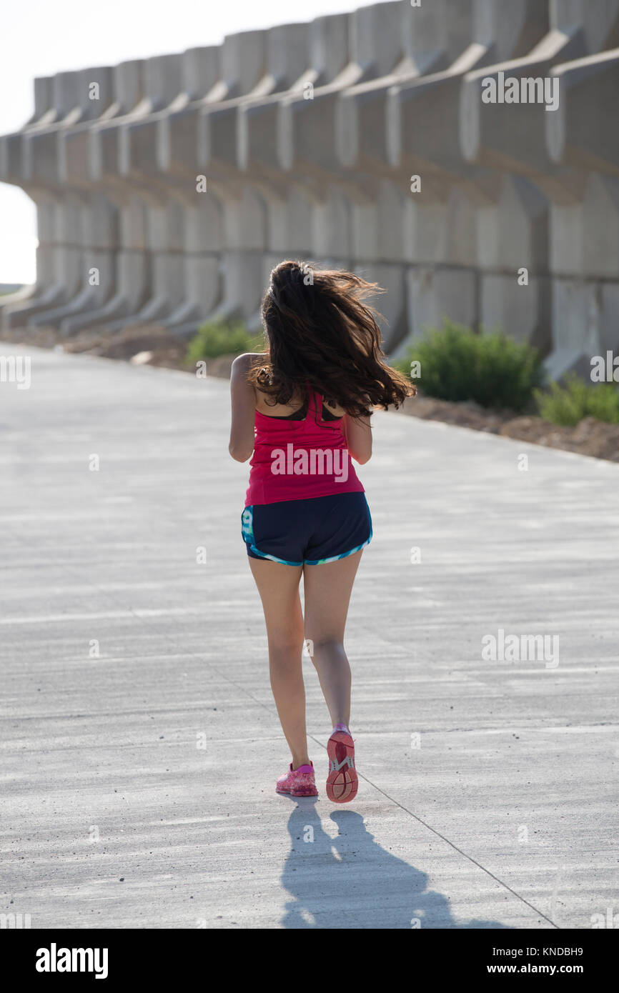Rear view of a young woman running outdoors Stock Photo - Alamy