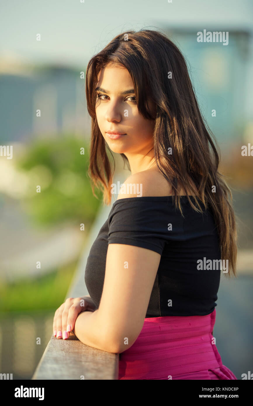 Beautiful young woman leaning on the rails outdoors Stock Photo - Alamy