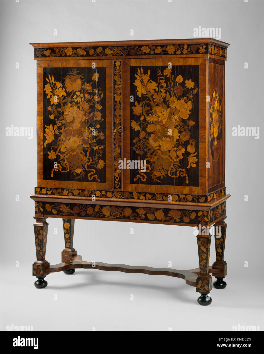 This cabinet on a stand showcases intricate woodwork and serves both as ...