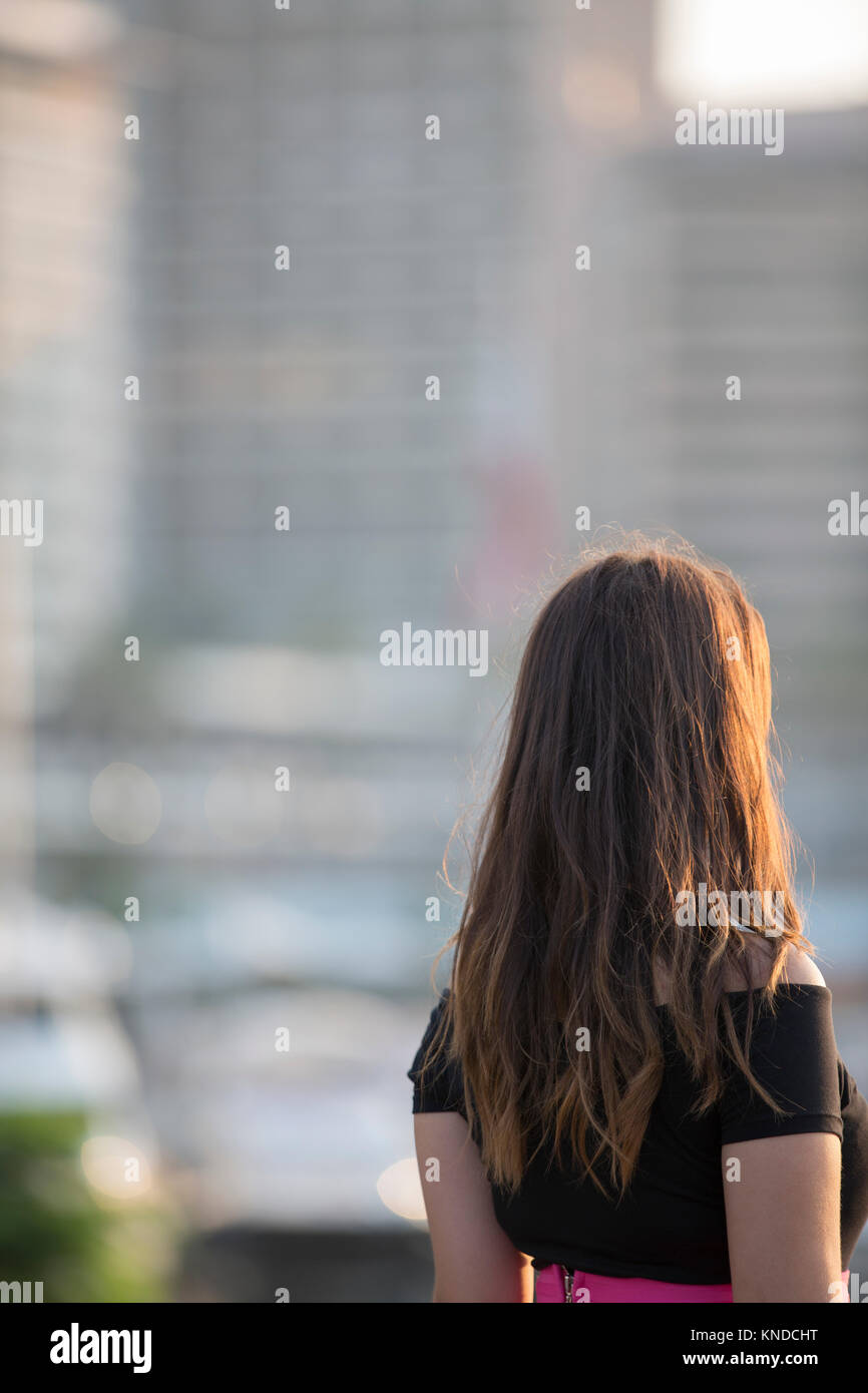 Rear view of a young woman standing outdoors Stock Photo - Alamy