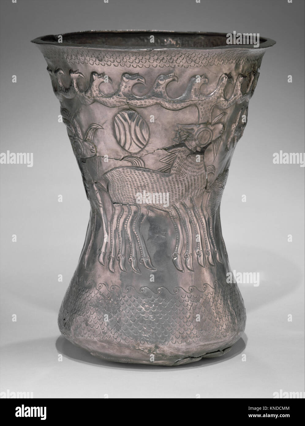 This beaker is decorated with intricate depictions of birds and animals ...
