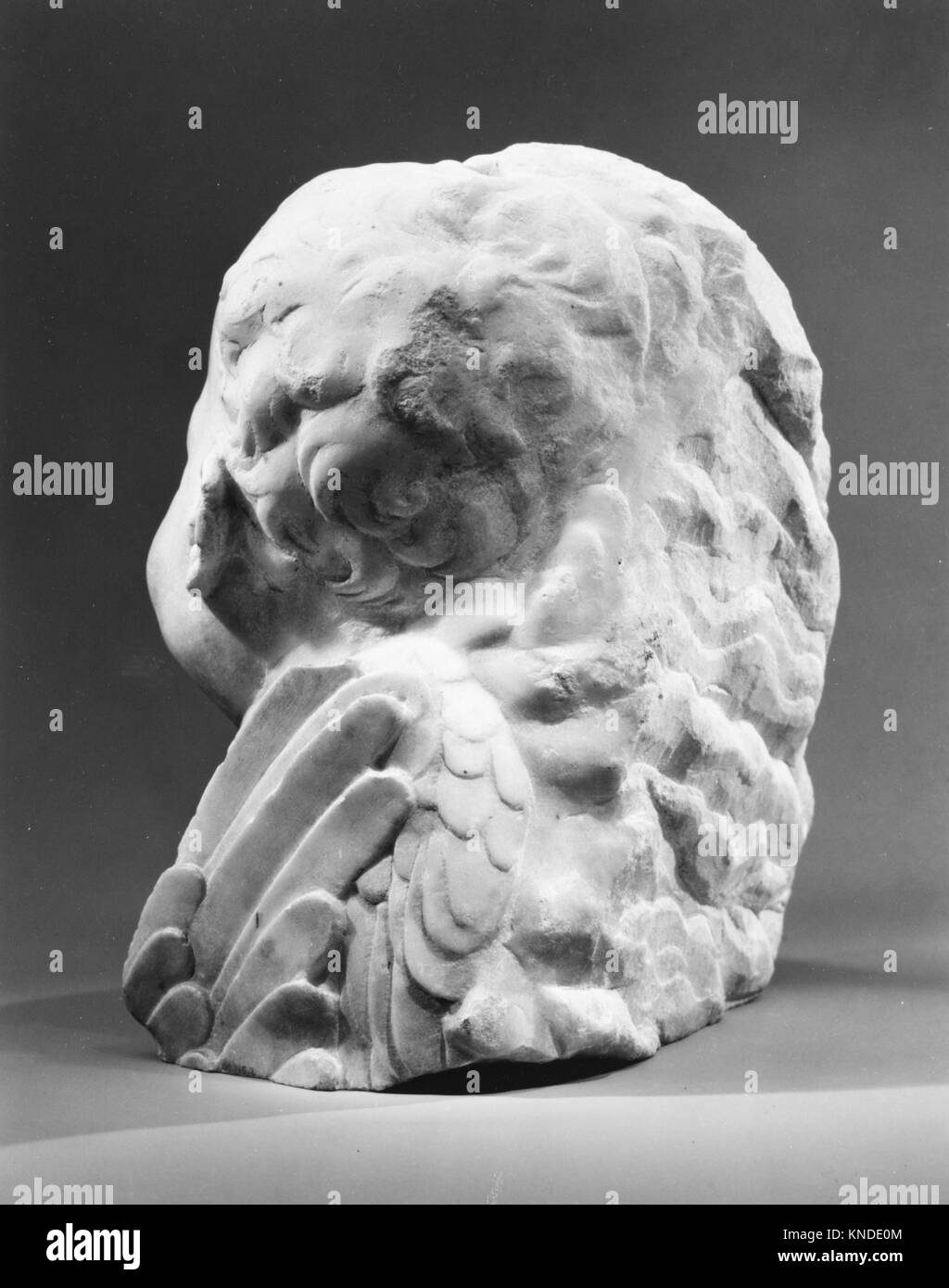 This sculpture features the head and wings of an angel, along with the ...
