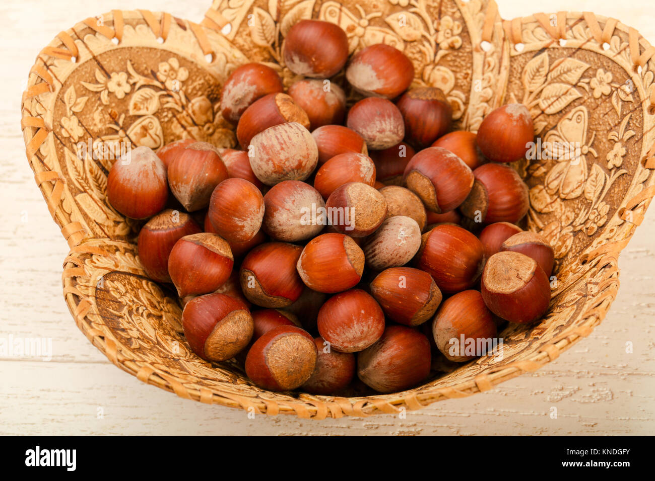 Hazelnut heap in the basket over wooden background Stock Photo - Alamy