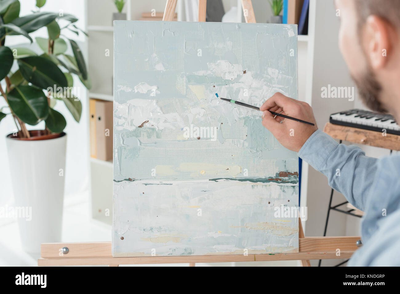 man painting on canvas Stock Photo - Alamy