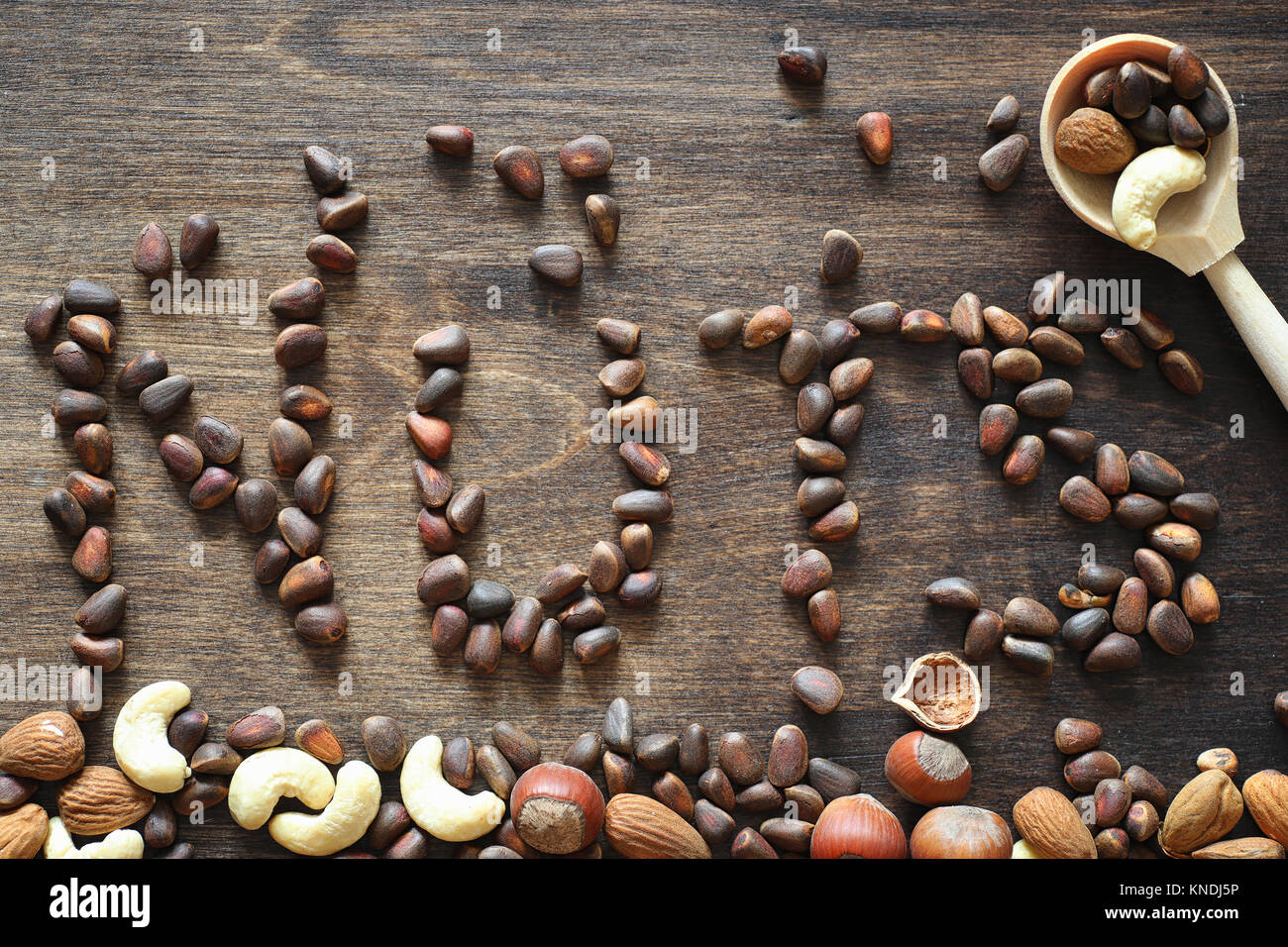 Different nuts on a wooden table. Cedar, cashew, hazelnut, walnu Stock ...