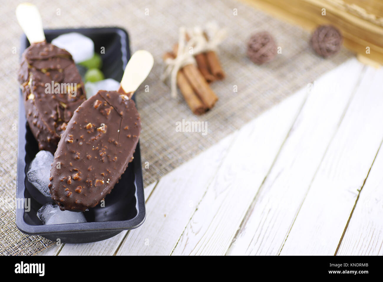 Dessert chocolate ice cream with nuts on wooden stick Stock Photo - Alamy