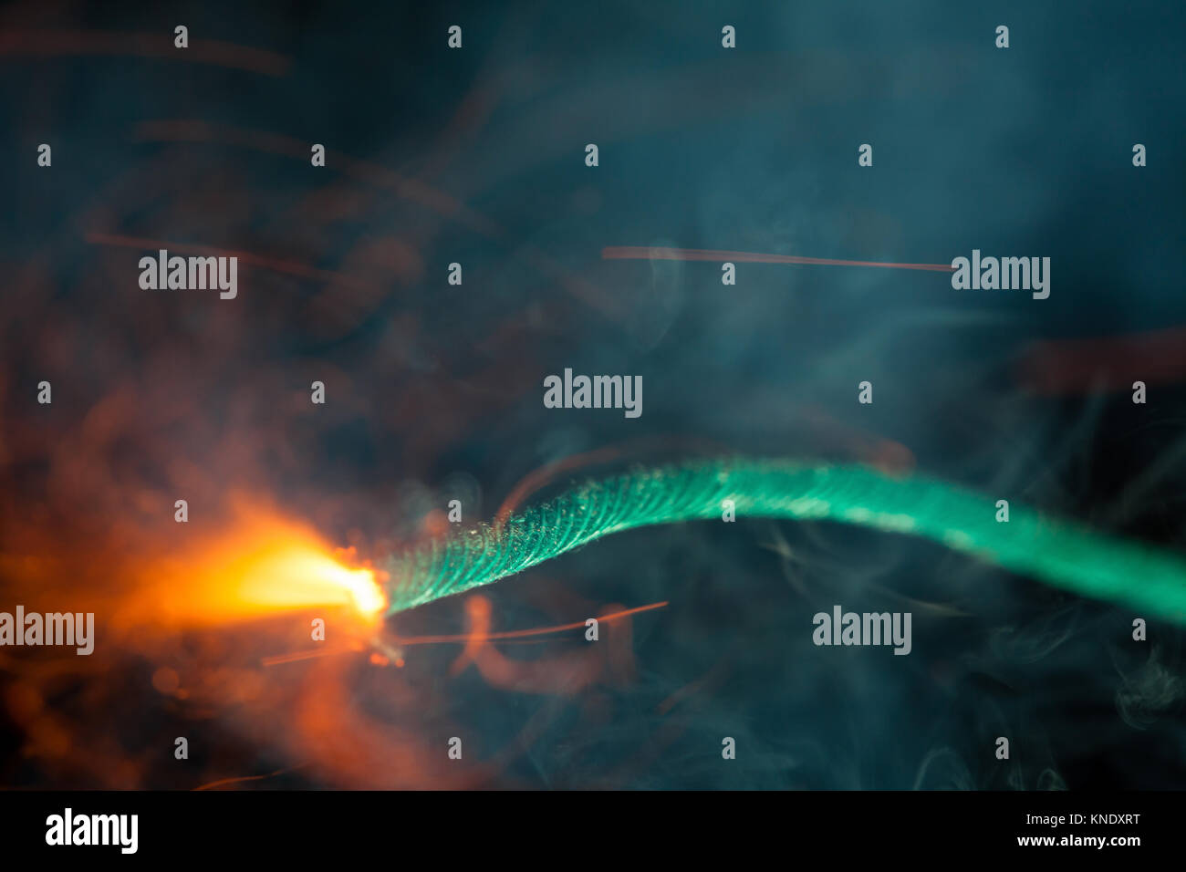 Close-up of burning fuse with sparks and lot of grey smoke on black ...