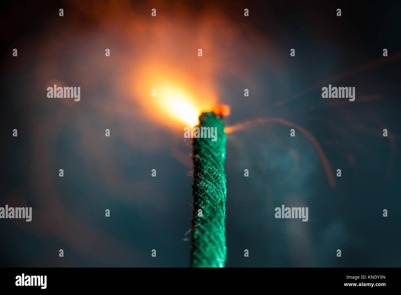 Close-up of burning fuse with sparks and lot of grey smoke on black ...