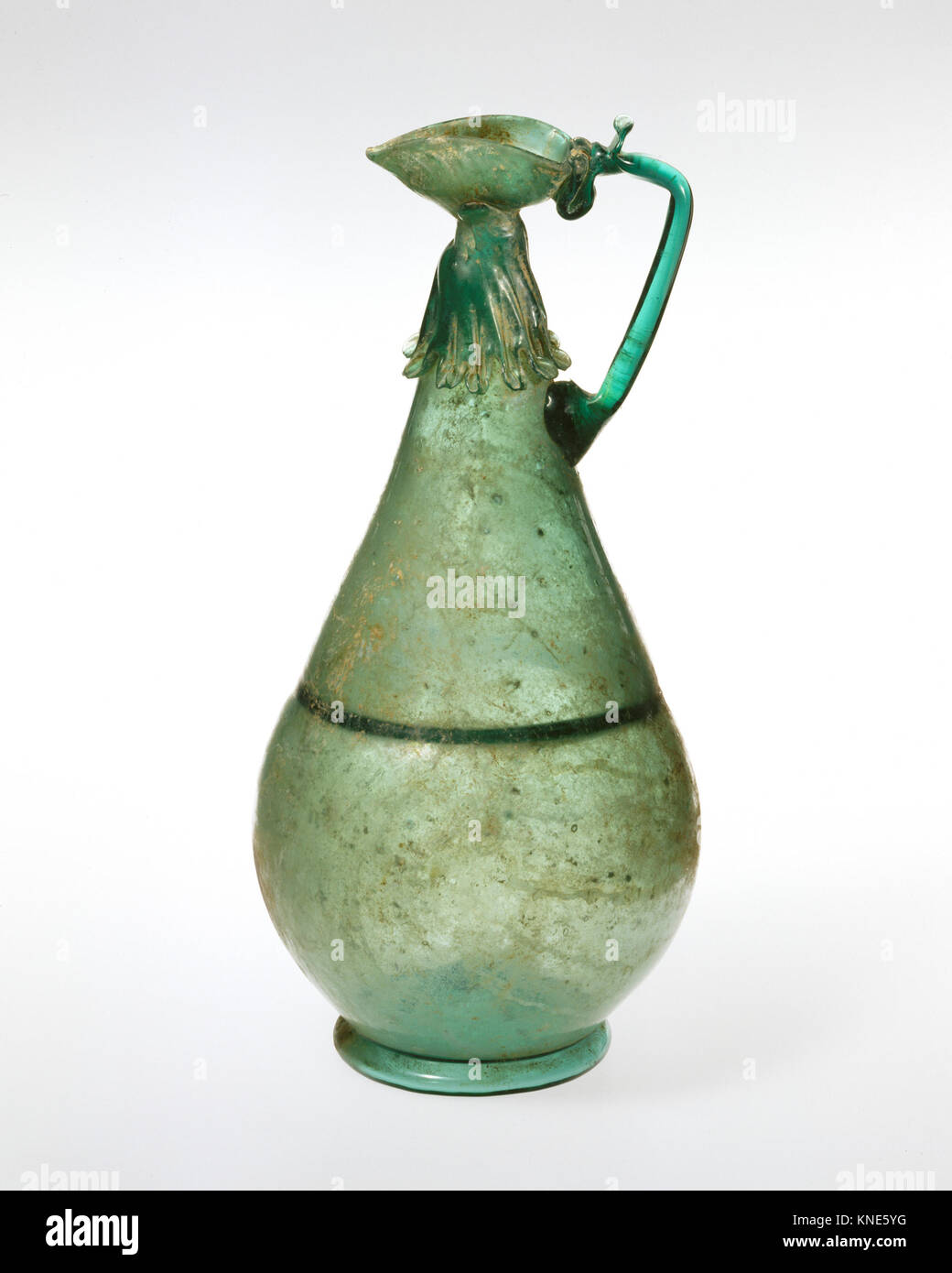This ewer, a type of pitcher, is crafted from metal and is an example ...