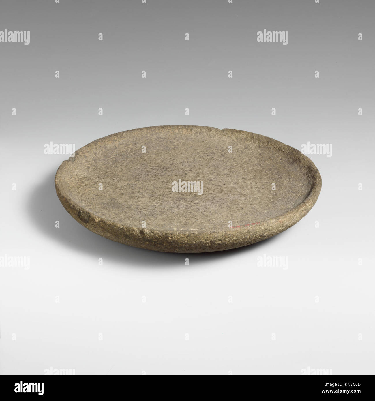 This basalt mortar or plate is an ancient tool used for grinding or ...