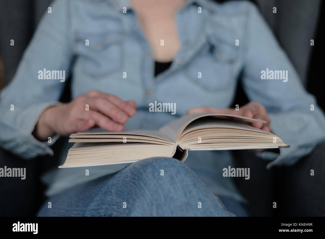 Woman sitting reading a book Stock Photo - Alamy