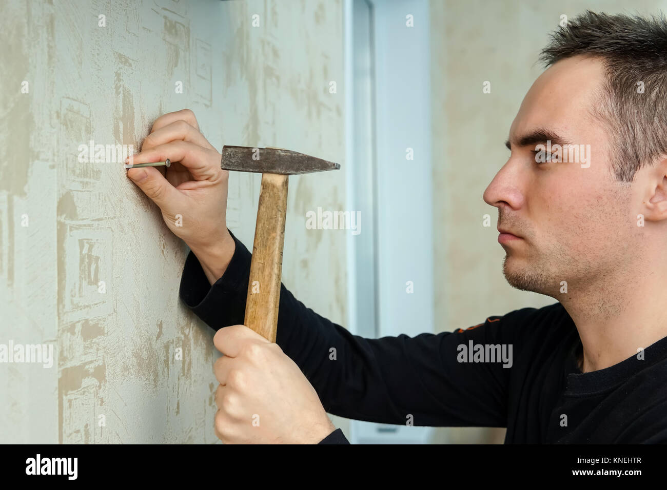 Handsome young man with hammer at home. guy doing renovation at home ...