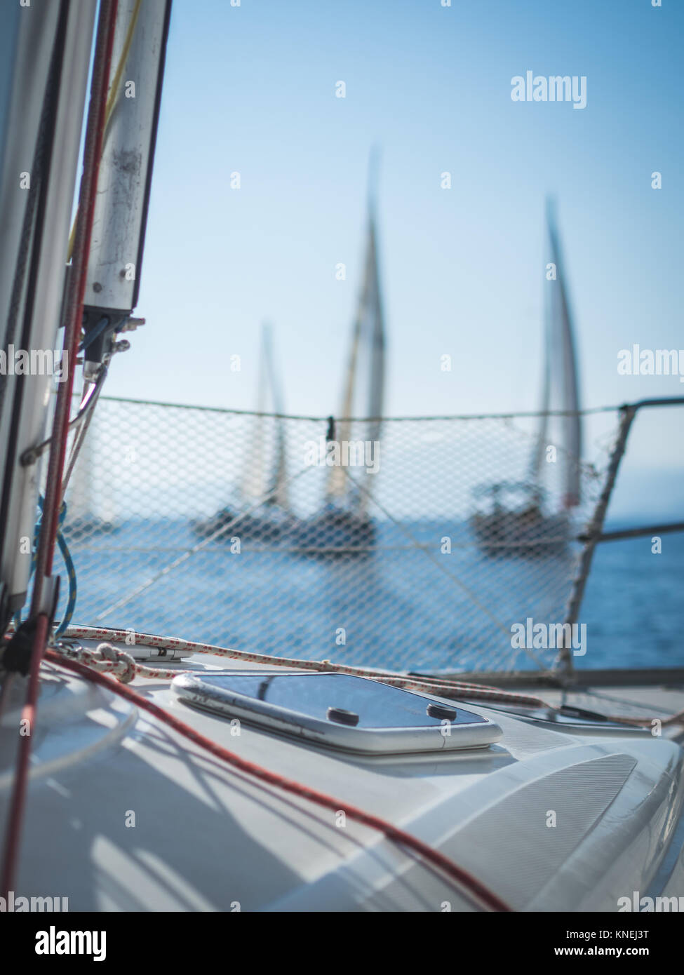 Window hatch on a sailing boat and boats racing in the background ...