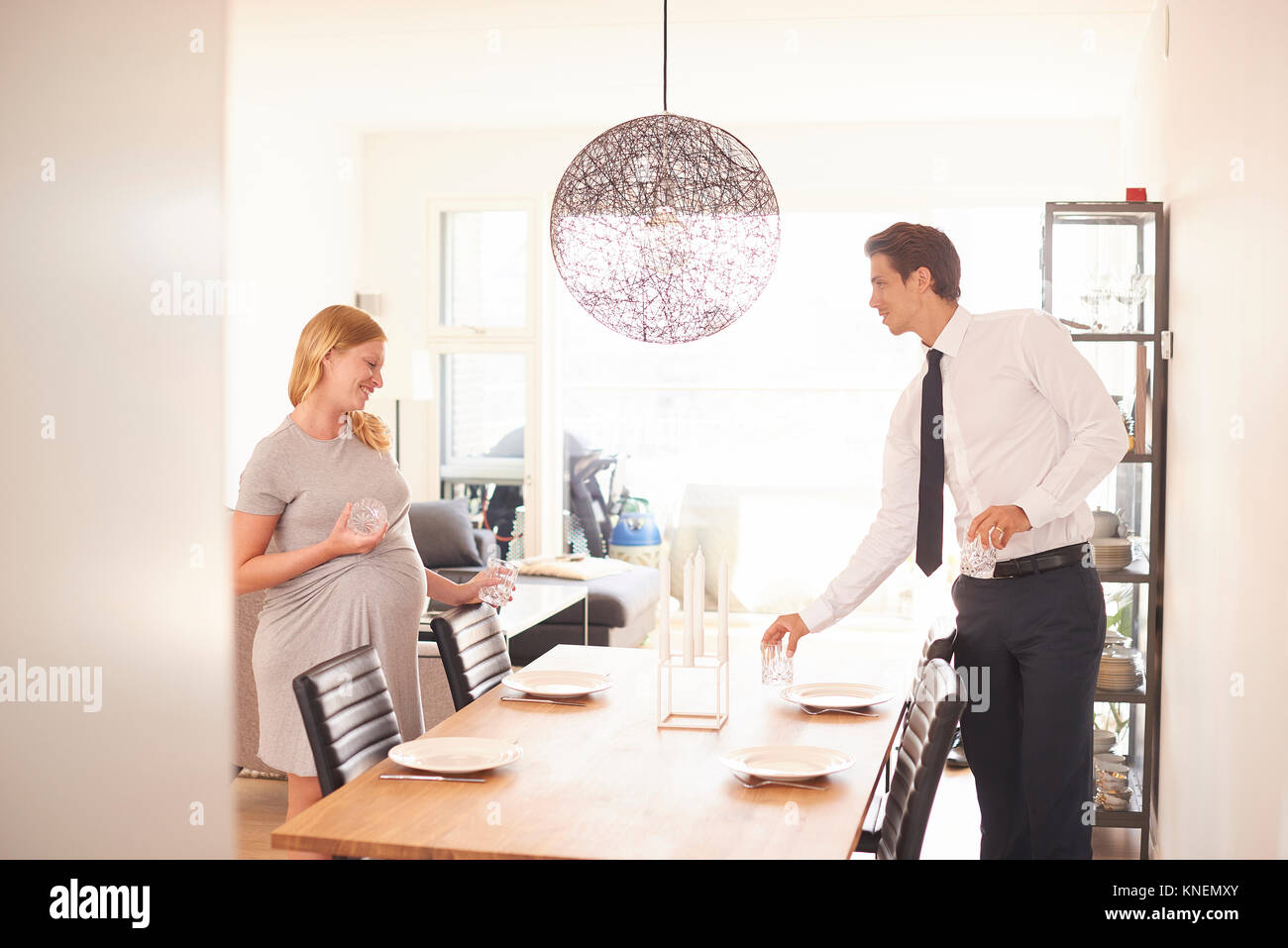 Pregnant couple laying dining table Stock Photo - Alamy