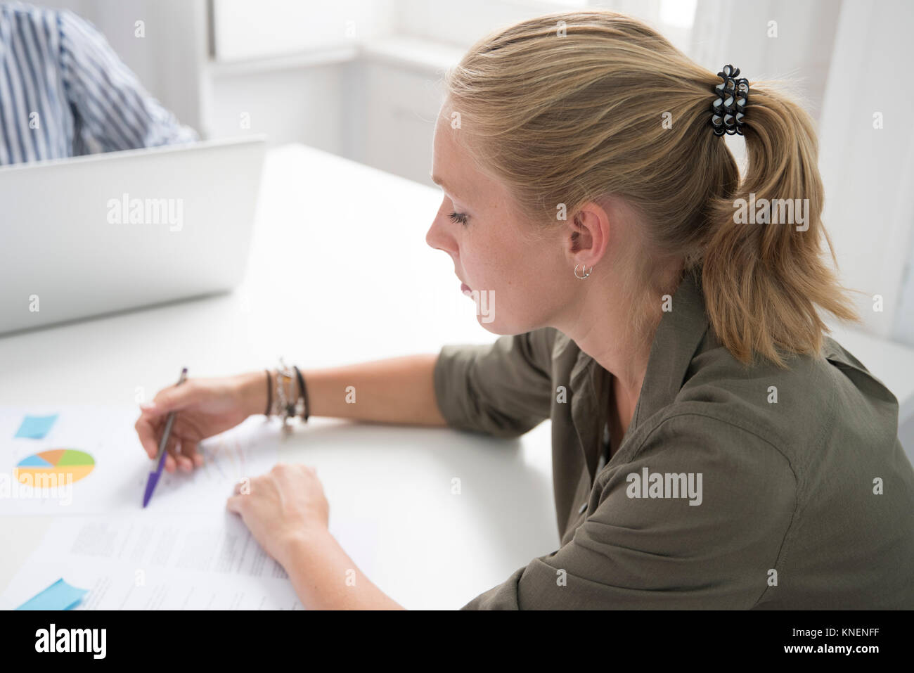 Young businesswoman making notes on paperwork at office desk Stock ...