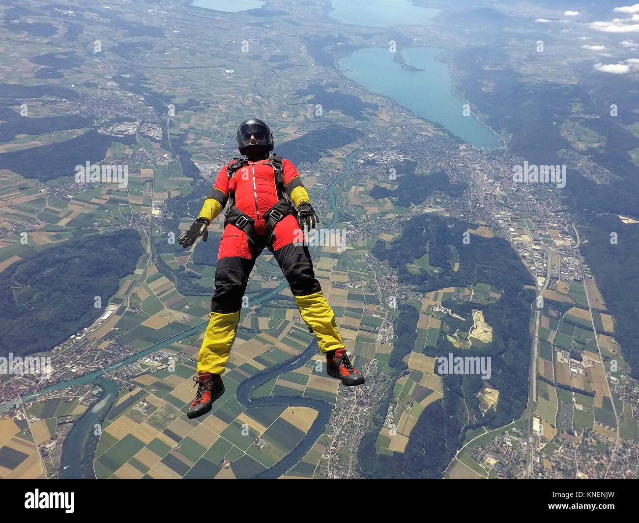 Female skydiver free falling on back above landscape Stock Photo - Alamy